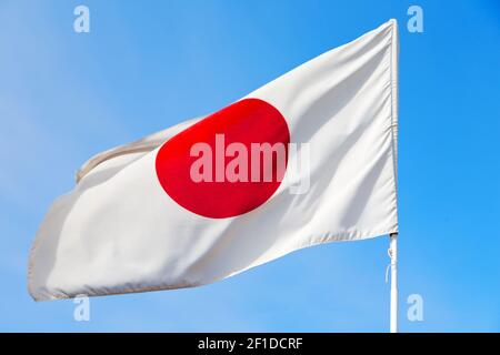 Japanb waving flag in the blue sky bcolour and wave Stock Photo - Alamy