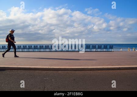 A woman walks past beach chairs at the Baltic Sea during rain falls in ...