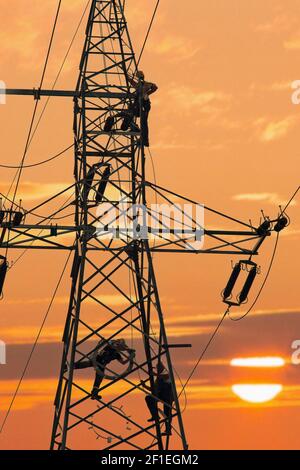 Electricians working on a power pole, filled with complex communication ...