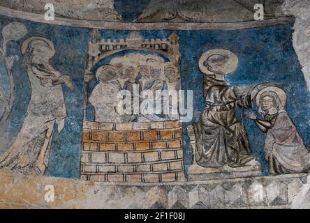 A tonsured monk looks up to heaven as he blesses a praying woman ...