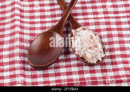 a silver metal spoon with too much salt in it on a marble table ...