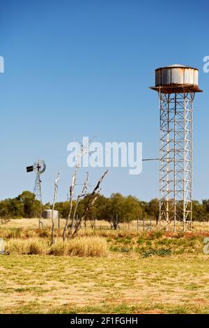 In the outback with asphalt line and water tank Stock Photo - Alamy