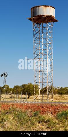 In the outback with asphalt line and water tank Stock Photo - Alamy