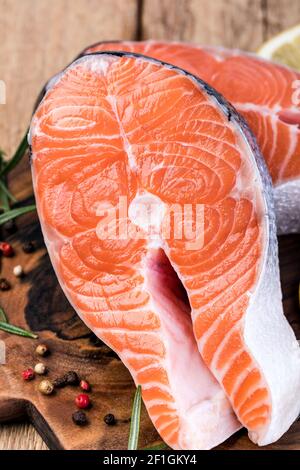 Slice of red fish salmon with lemon, rosemary and peppercorns isolated ...