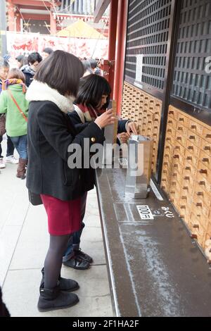 Reading Omikuji, fortune-telling paper strips, at Hikawa Jinja shinto ...