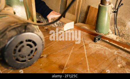 Worker uses circular saw to cut wood on construction project outside ...
