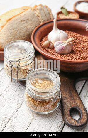 Bowl with buckwheat grains and garlic on grey table Stock Photo - Alamy