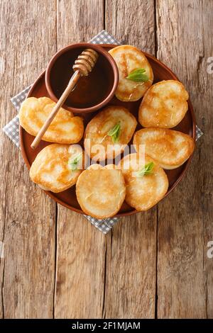 Authentic Tiganites Greek pancakes with honey close-up in a plate on ...