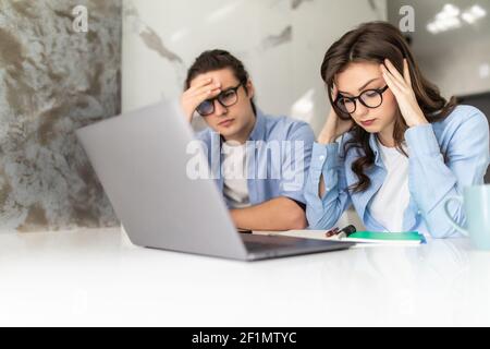 Sad couple with financial problems and troubles showing the calculator ...