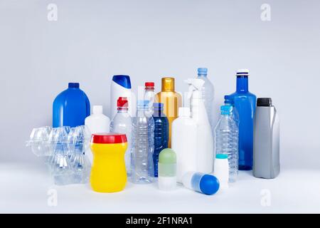 Many plastic containers of different shapes and colors isolated on ...