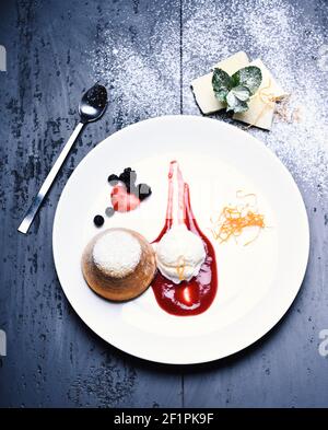 Dessert served with orange noodles in cafe or bakery. Molten lava cake ...