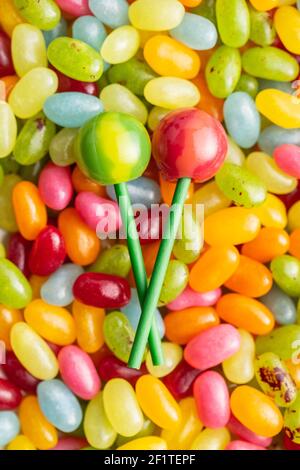 Sweet fruity lollipops and jelly beans on white table. Top view Stock ...