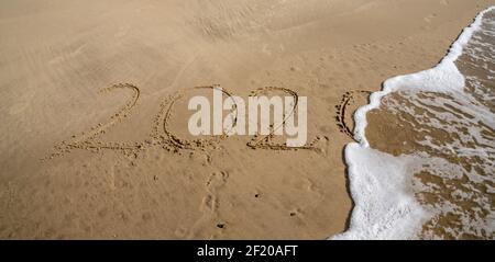 2020 written on the sand of a beach, travel 2020 new year concept Stock ...