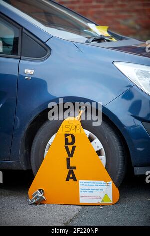 An un taxed vehicle is clamped on a street by the DVLA. The vehicle has ...