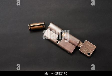 Cylinder lock with removed core and inserted key on black background ...