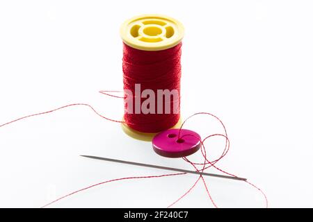 Button with two holes. Thin red thread Stock Photo - Alamy