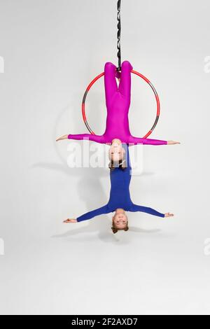 two gymnast child girls show athletic skills on white studio background ...