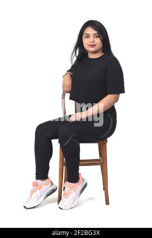 Latin woman wearing sportswear sitting sideways and legs crossed on ...