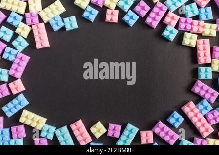 Plastic toy blocks on black background Stock Photo - Alamy