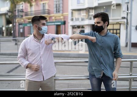 Spanish men wearing masks and greeting each other with elbows - new ...