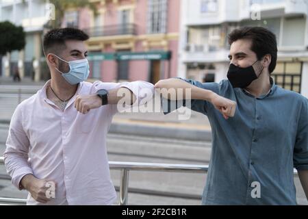 Spanish men wearing masks and greeting each other with elbows - new ...