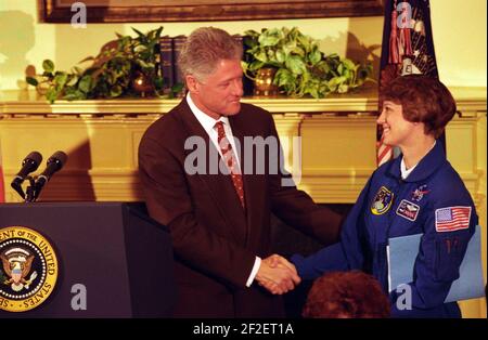 President Bill Clinton shakes hands with school children during a ...