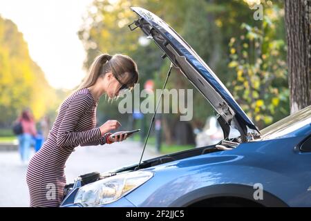 Unhappy young woman waiting angrily while her friend is talking happily on sellphone with ...