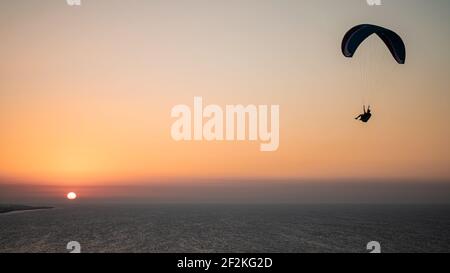 Amazing paragliding in sunset Stock Photo - Alamy