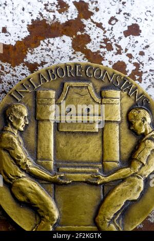 Bronze medal, with two workers and the words "Hard workers ...