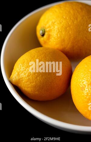 Plate with fresh lemons on light background Stock Photo - Alamy