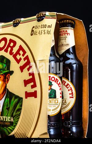 6 pack of Birra Moretti beer on wooden barrel with dark background ...