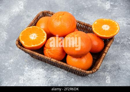 A wicker box full of juicy orange fruits on stone background Stock ...