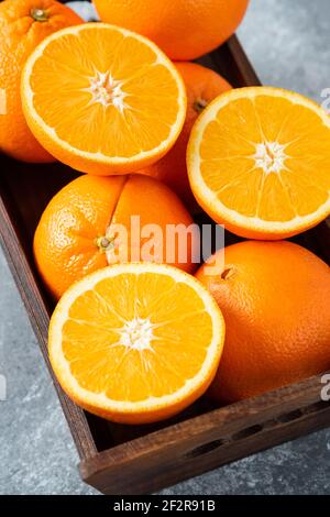 A wooden old box full of sliced and whole juicy orange fruits Stock ...