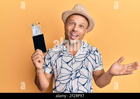 Handsome muscle man holding boarding pass and passport pointing thumb ...