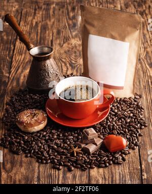 blue cup of coffee, macaroons and donut heart-shaped beans on wooden ...