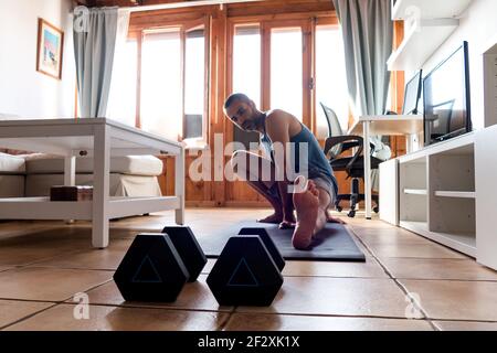 Young caucasian man stretching at sport center Stock Photo - Alamy