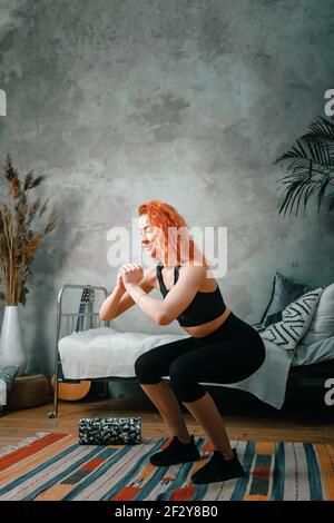 Pretty fitness girl doing squats with a barbell on her shoulders in the ...