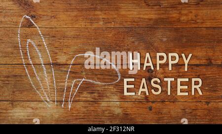 Chalk-drawn ears. Rabbit ears on a wooden background. Happy easter ...