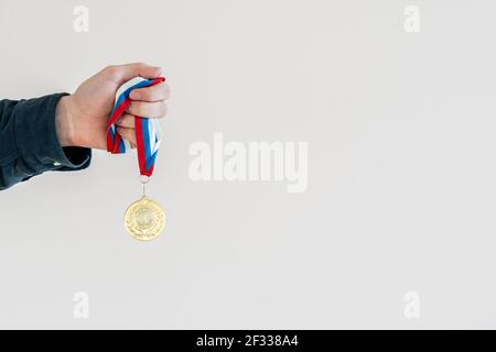 a campion's hand holding a golden medal, simple winner lucky concept ...