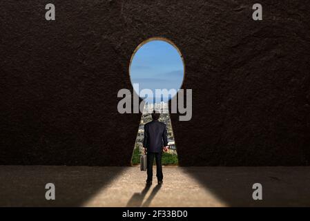 Businessman standing in front of keyhole Stock Photo - Alamy