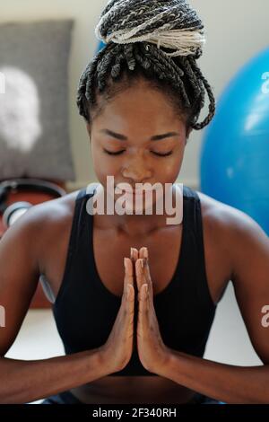 Mindful young african woman meditating thinking and opening eyes ...