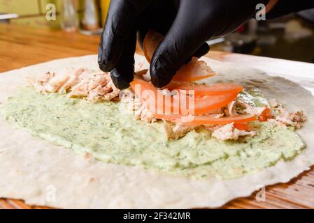 Burrito cooking process. Cook adds meat to pita with sauce. The process ...