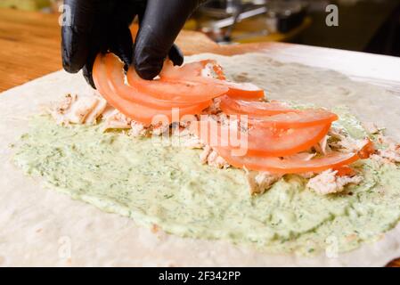 Burrito cooking process. Cook adds meat to pita with sauce. The process ...