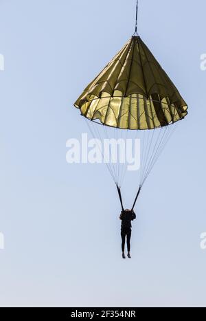 Parachuting sport concept. Skydiver descending with a parachute Stock ...