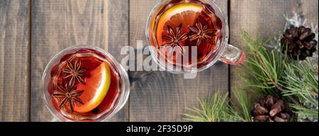 banner with two cups with mulled wine on wooden table with warm knit ...