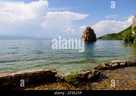 Large rock surrounded by water along the shore of a lake Stock Photo ...