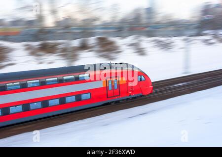 High speed double decker express train arrives at a station in the city ...