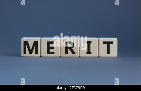 Merit symbol. Wooden cubes with the word 'merit'. Businessman hand ...