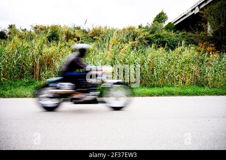 Side view of a blurred vintage motorbike on country road Stock Photo ...