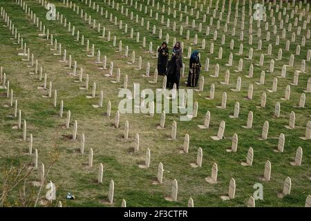 Halabja, Iraq. 16th Mar, 2021. A man sits in the graveyard of the ...